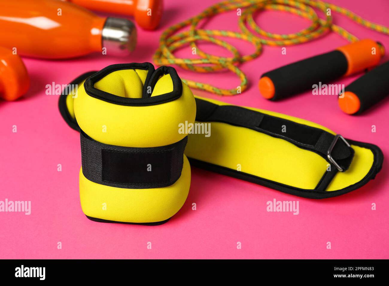 Yellow ankle weights and sport equipment on pink background Stock Photo ...