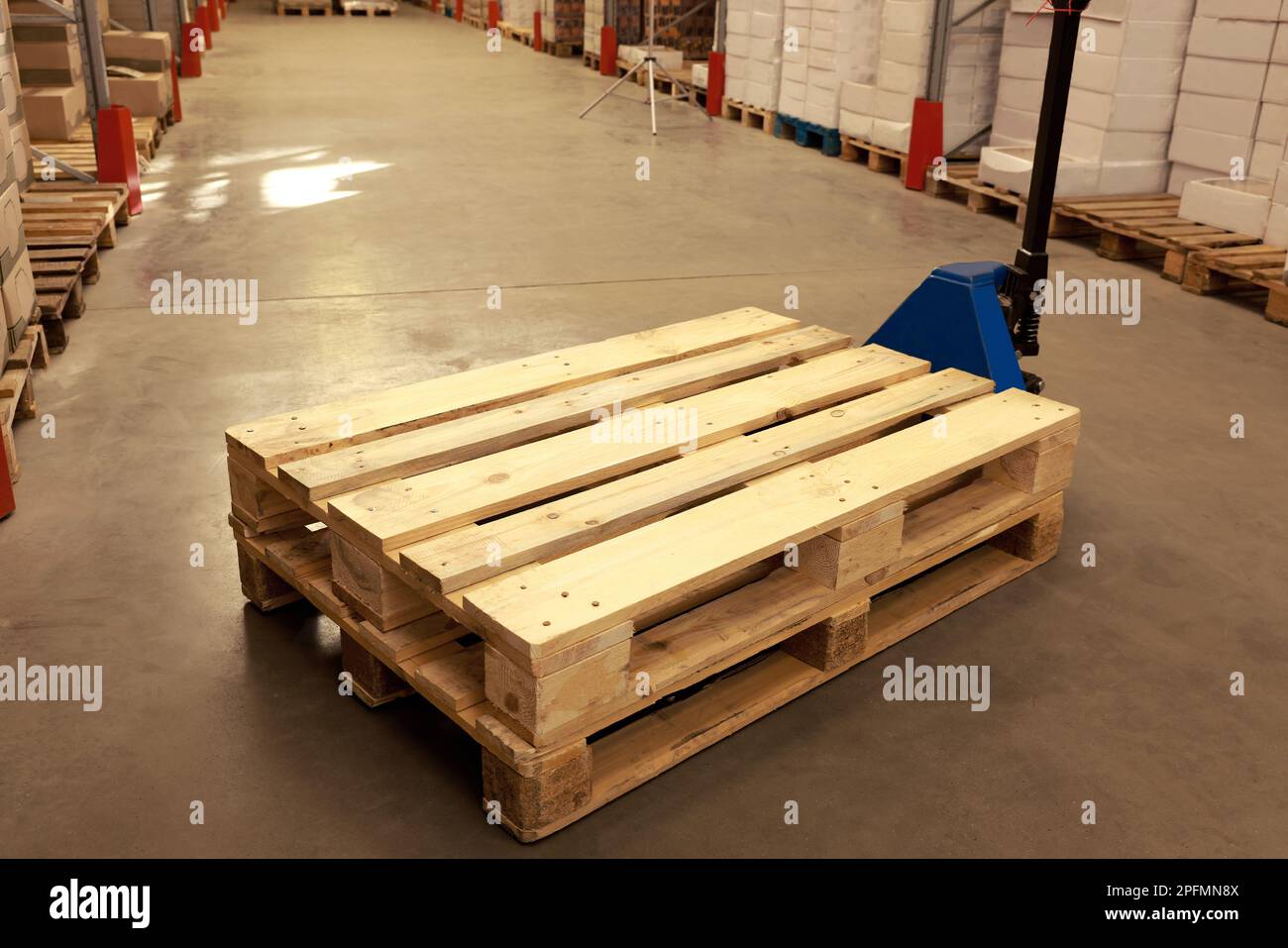 Modern manual forklift with wooden pallets in warehouse Stock Photo - Alamy