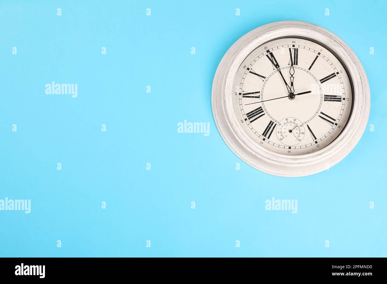 Stylish vintage wall clock showing five minutes until midnight on ...