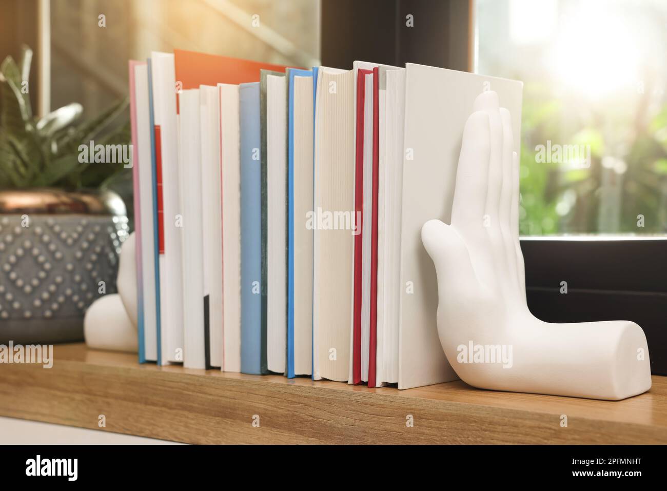 Beautiful hand shaped bookends with books on window sill indoors Stock ...
