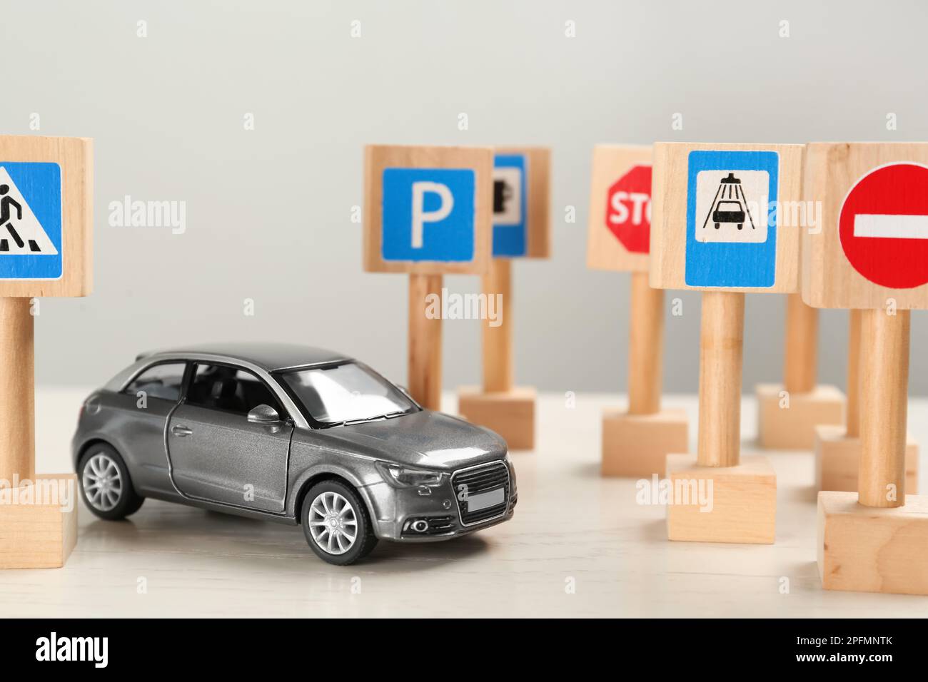 Miniature road signs and car on white table. Driving school Stock Photo ...