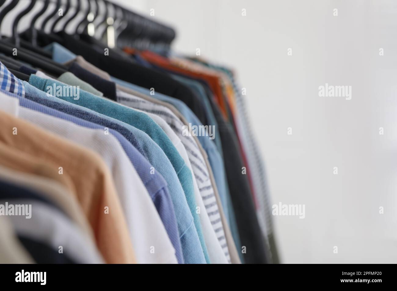 Rack with stylish clothes on white background, closeup. Fast fashion ...