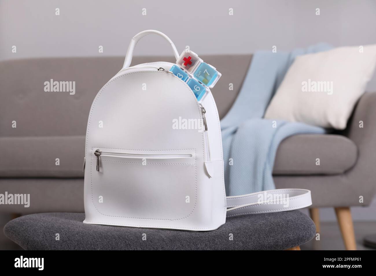 Stylish women's backpack with plastic pill box in room Stock Photo - Alamy