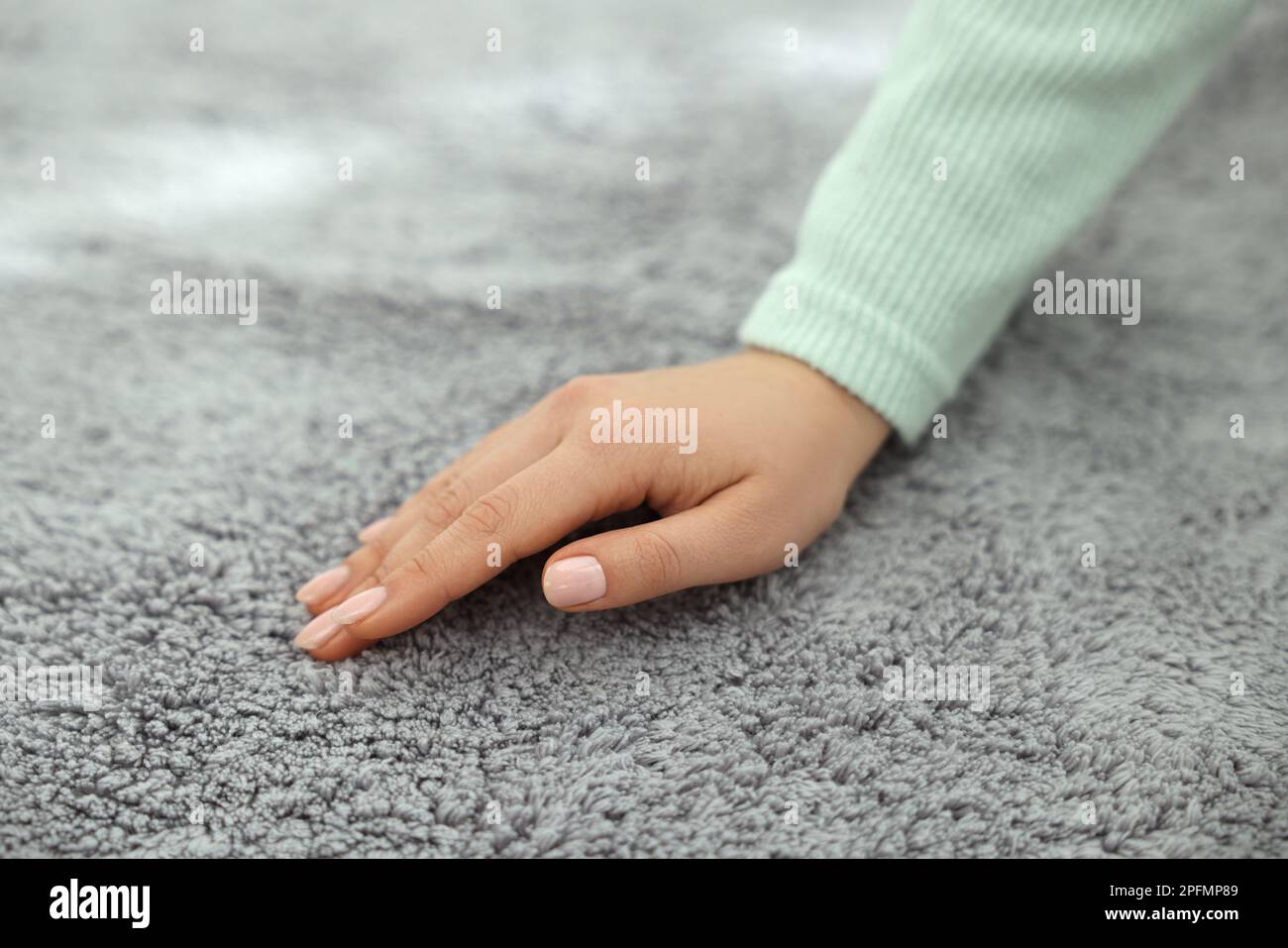 Woman touching soft grey carpet, closeup view Stock Photo - Alamy