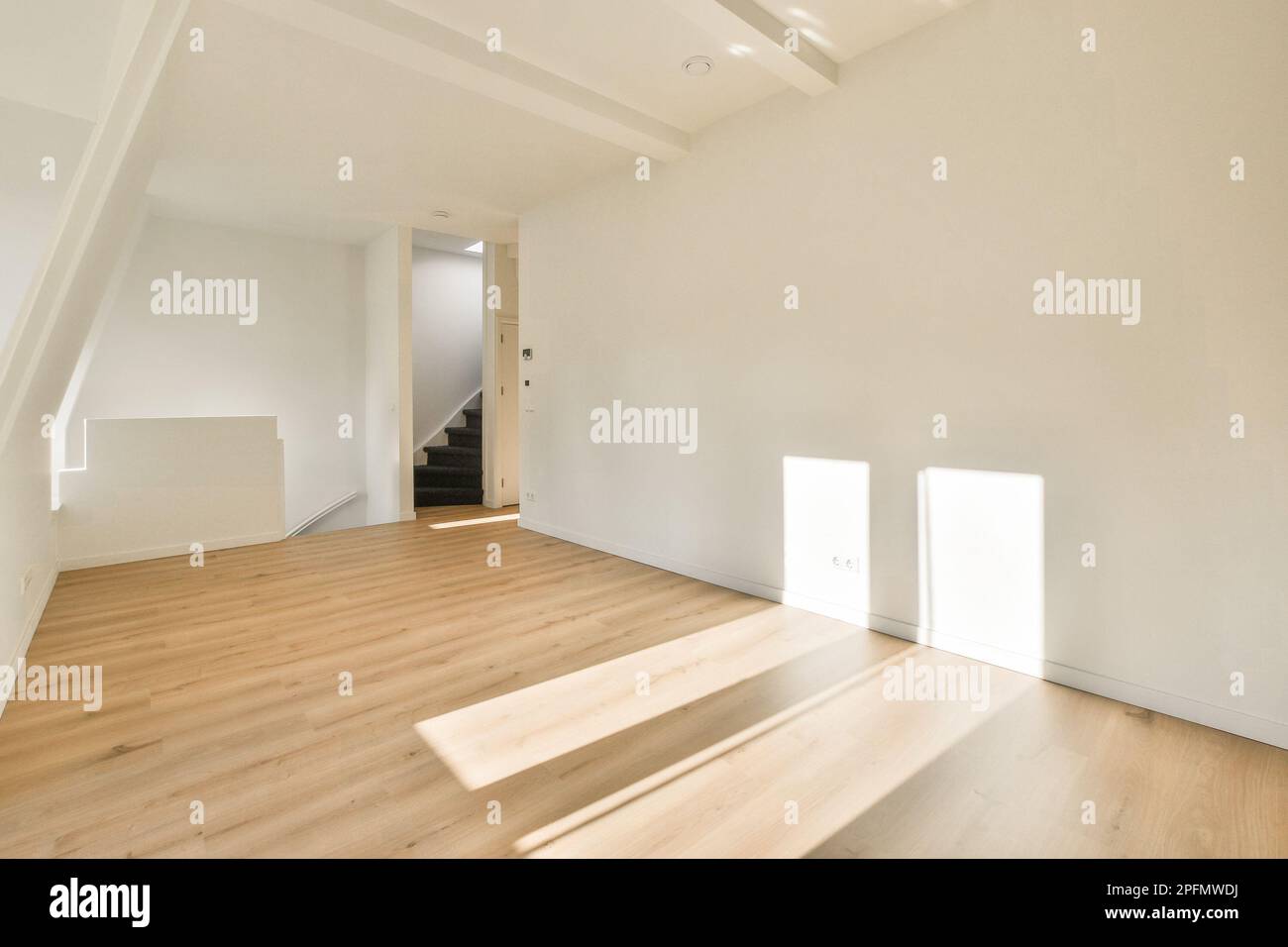 an empty room with light coming in through the window and wood flooring ...