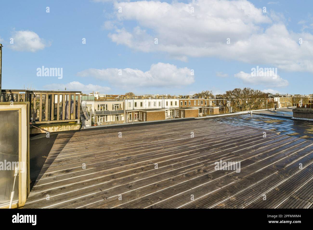 a roof with some buildings in the background and blue sky above it, as ...