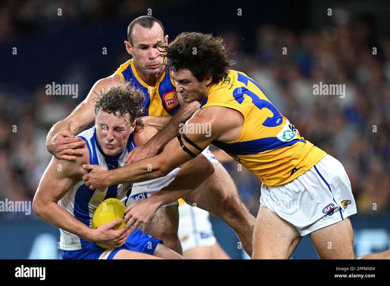 Nick Larkey of North Melbourne (left) is tackles by Shannon Hurn and ...