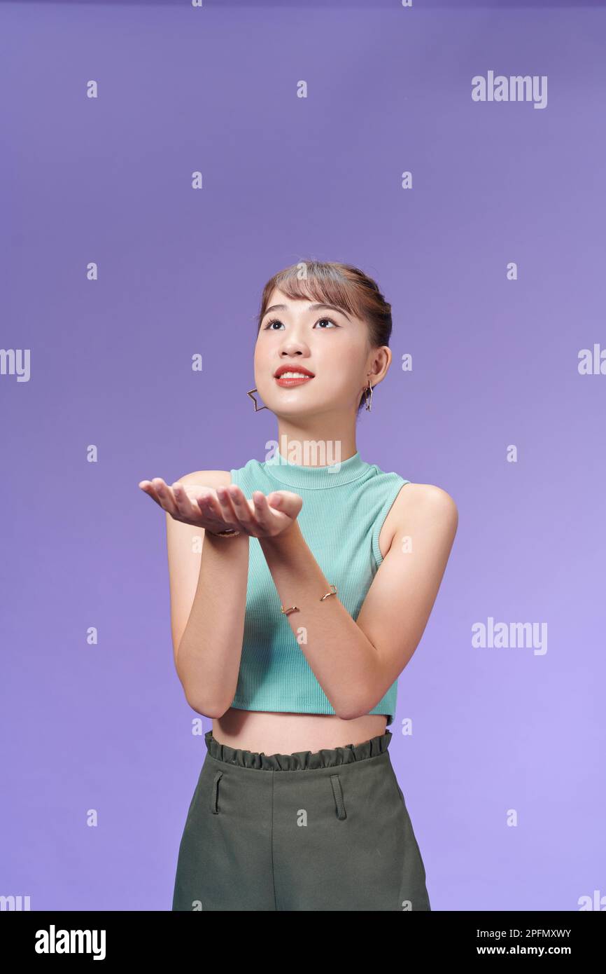 Young pretty woman holding something with hands, showing a product ...