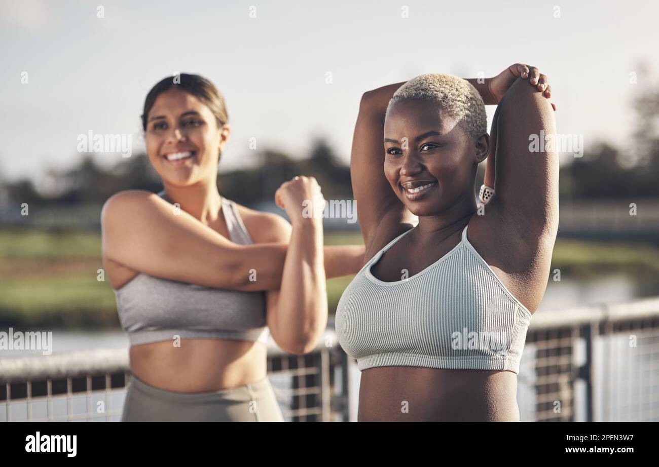 Stretch and you wont have any regrets. two young women stretching while ...