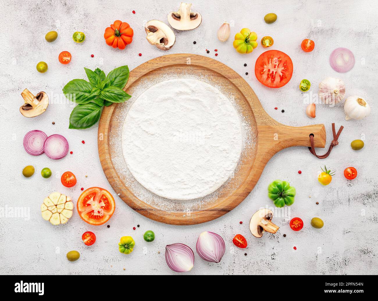 The ingredients for homemade pizza set up on white concrete background ...