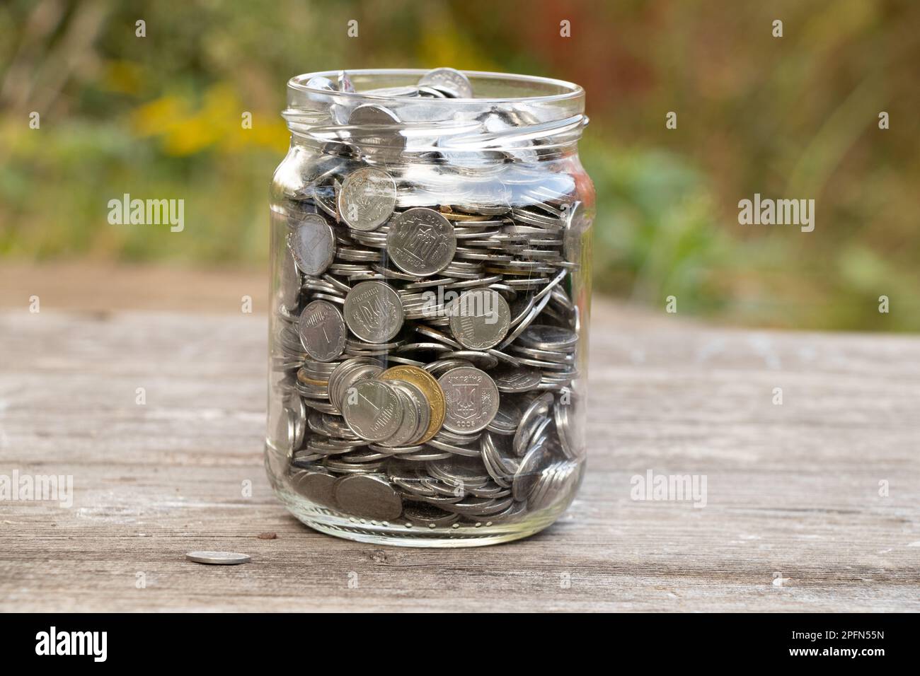 throw Ukrainian coins into a transparent glass jar, pour money into the ...