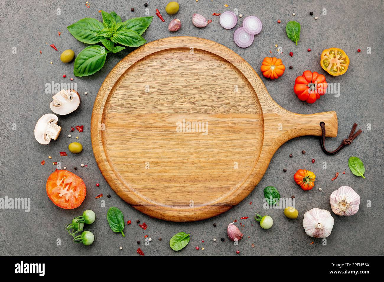 The ingredients for homemade pizza set up on dark stone background ...