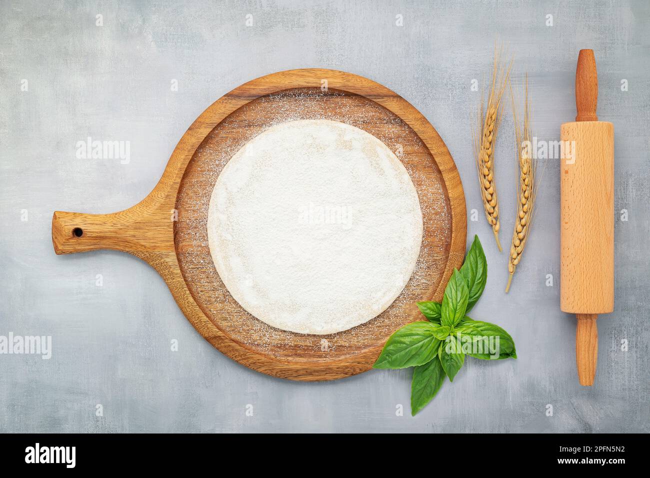 Empty wooden pizza platter set up on grey concrete. Pizza tray on grey ...