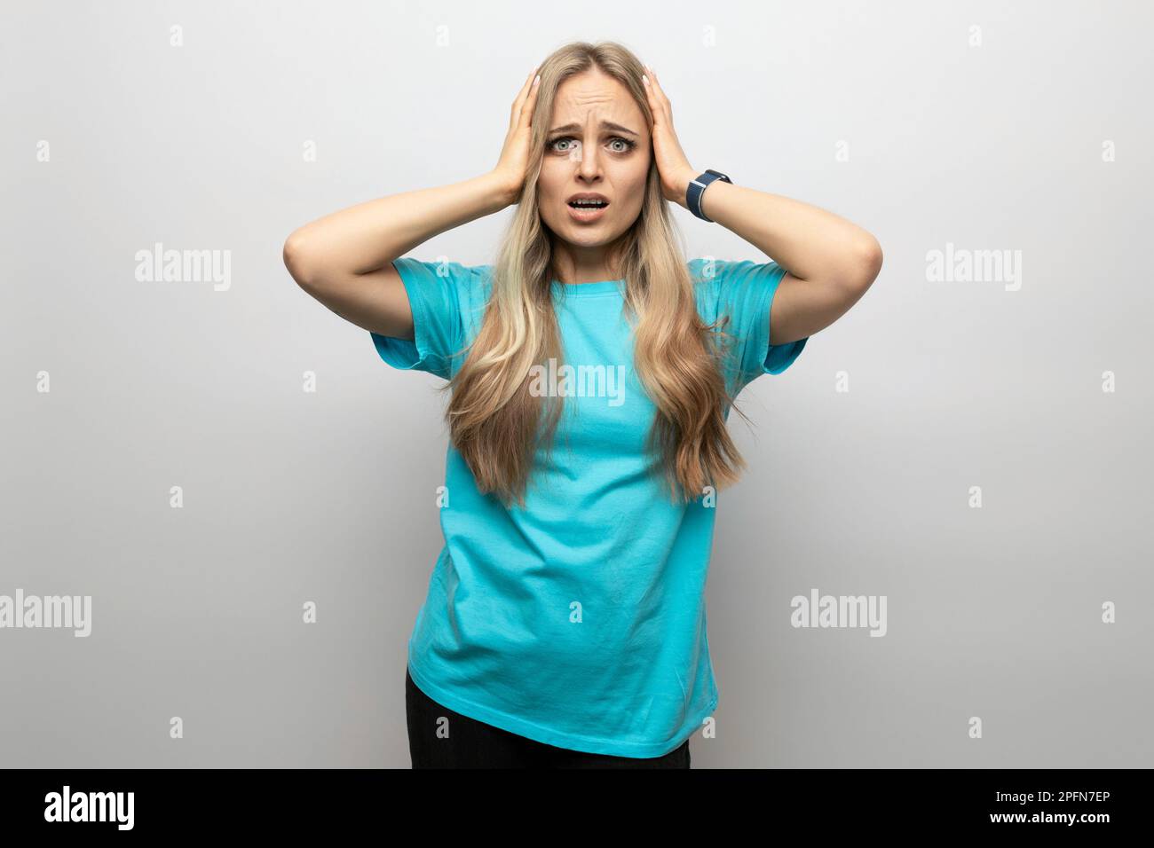 a young woman has a cracking head on a white background Stock Photo - Alamy