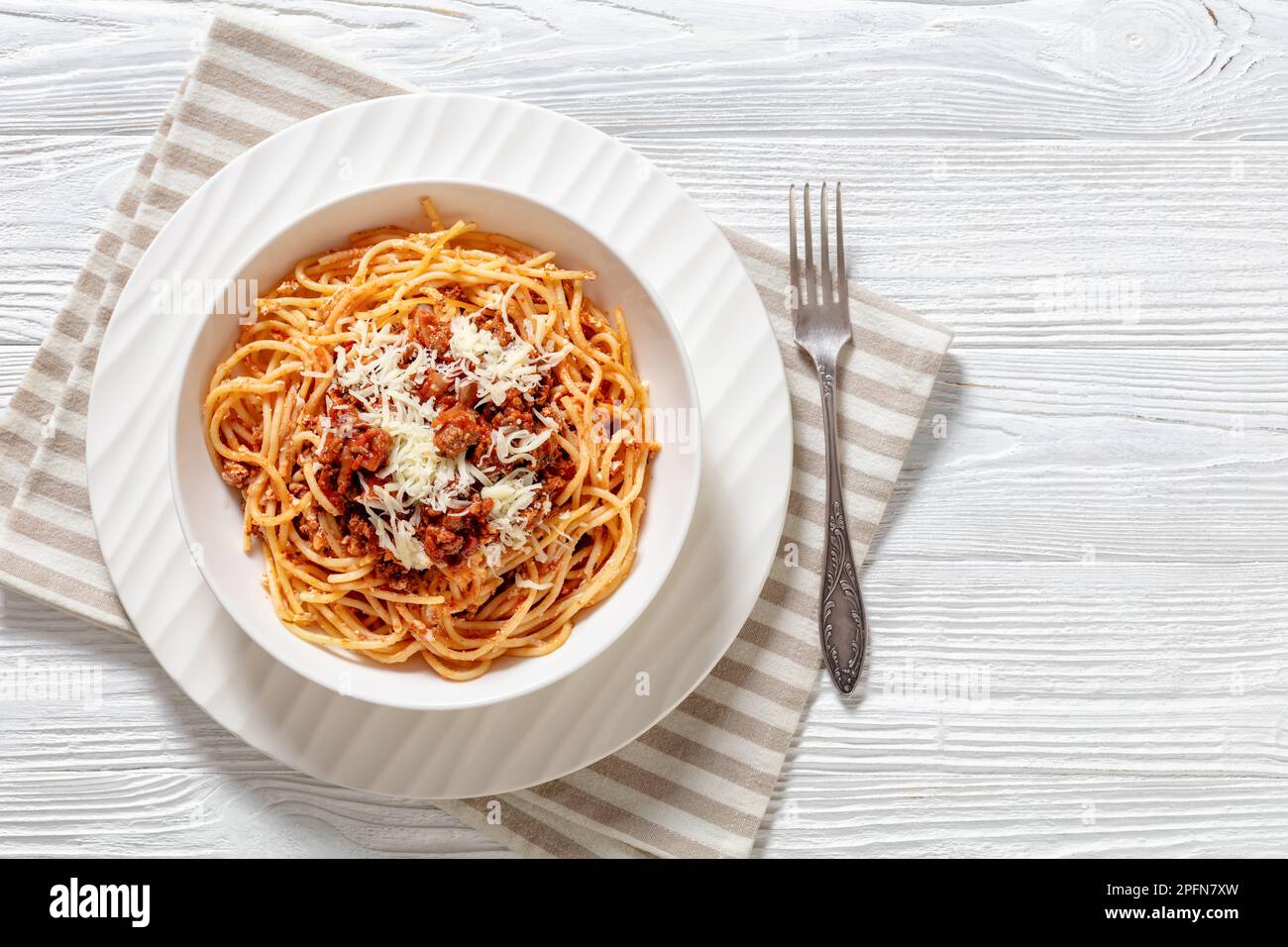 spaghetti al ragu alla Bolognese topped with shredded cheese in white ...