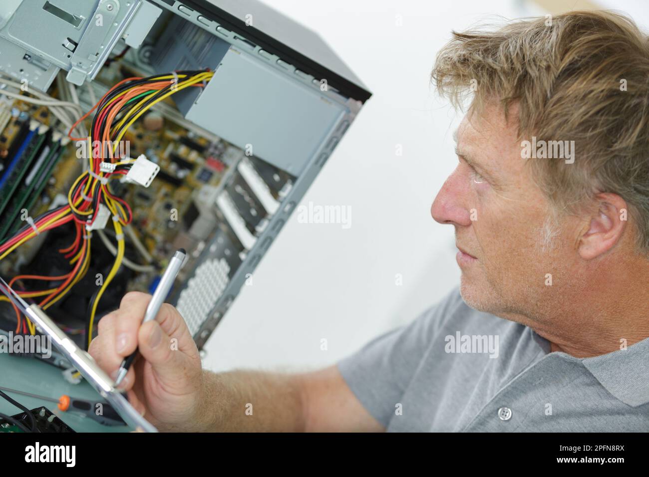 mature man fixing a pc Stock Photo - Alamy