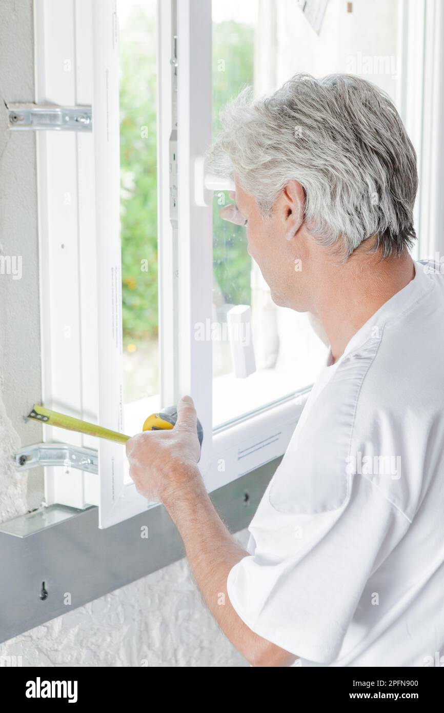man is measuring a window aperture Stock Photo - Alamy