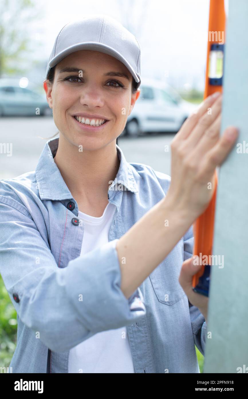 female checking level of the wall with the spirit level Stock Photo - Alamy