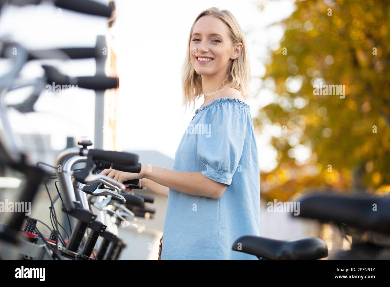 woman taking a bicycle in a bike rental platform Stock Photo - Alamy