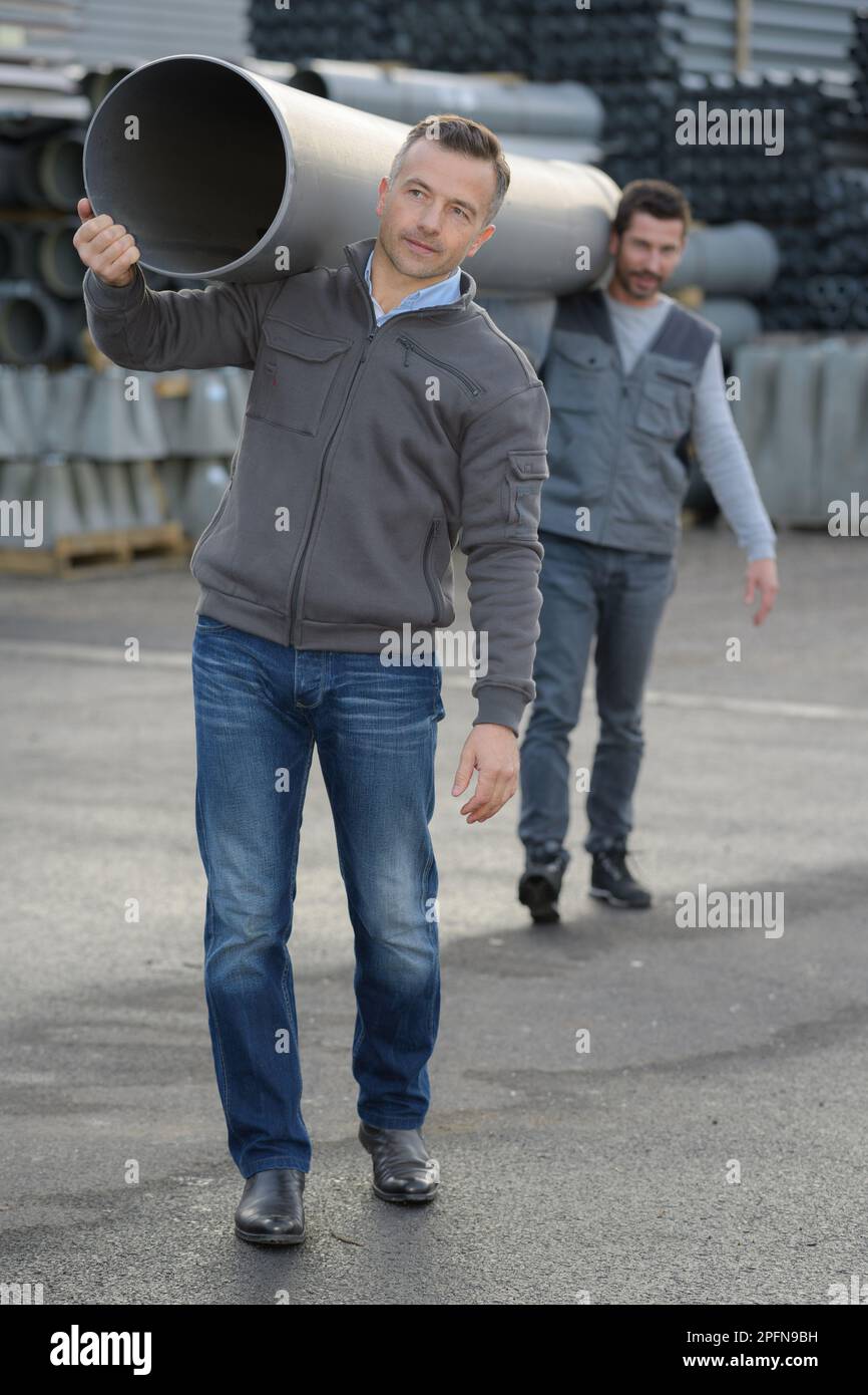Construction worker carrying pipes hi-res stock photography and images - Alamy