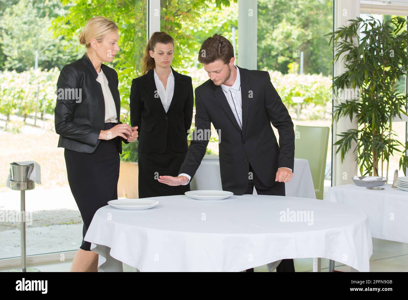 Waiting staff setting restaurant table Stock Photo - Alamy