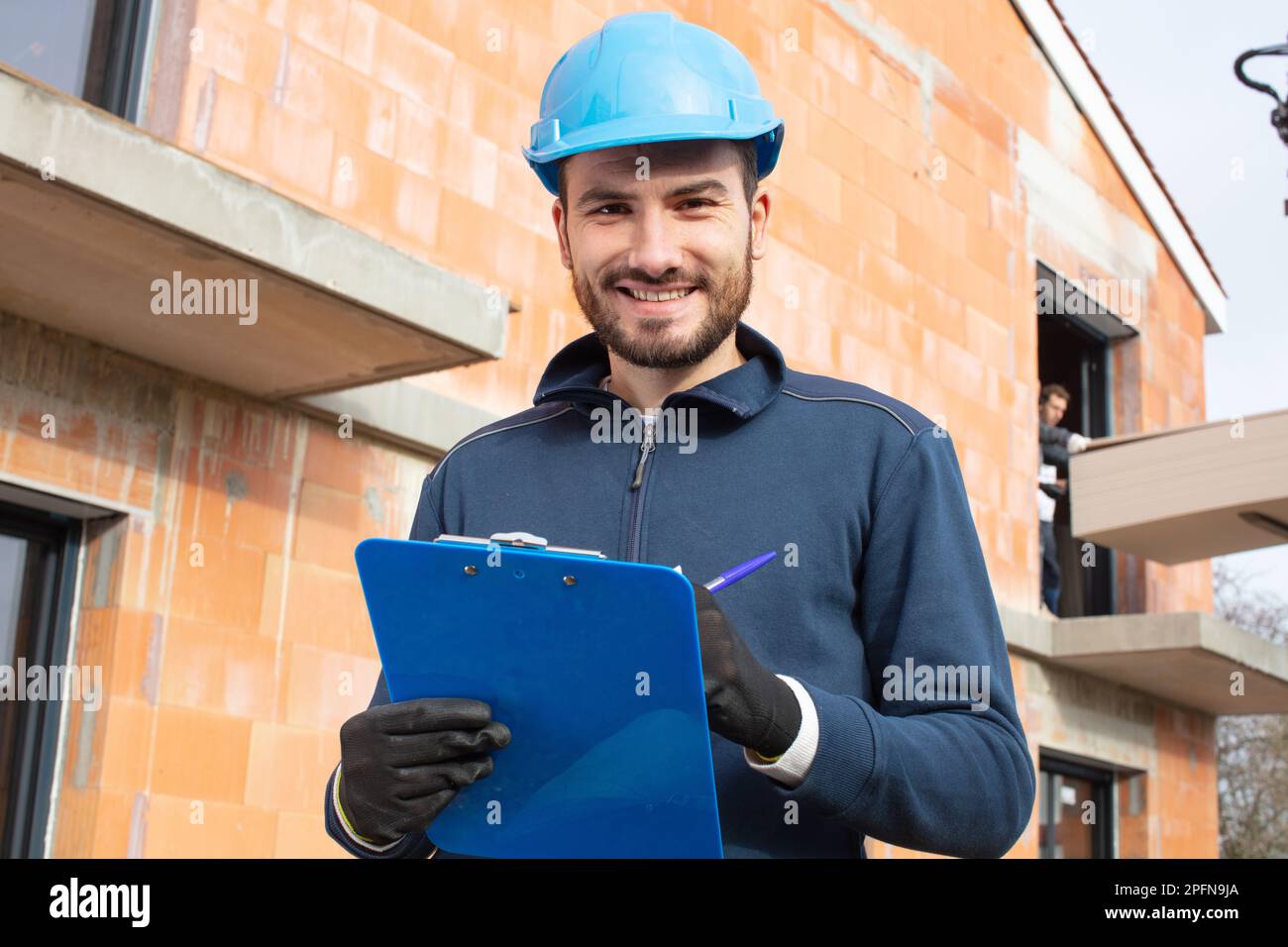 male builder holds clipboard estimated property value concept Stock ...