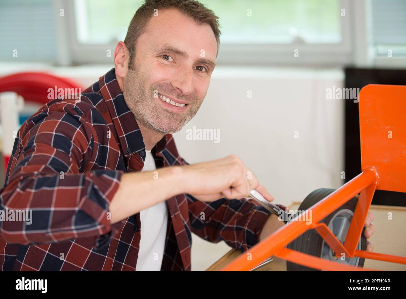 happy man fixing the trolley wheels Stock Photo - Alamy