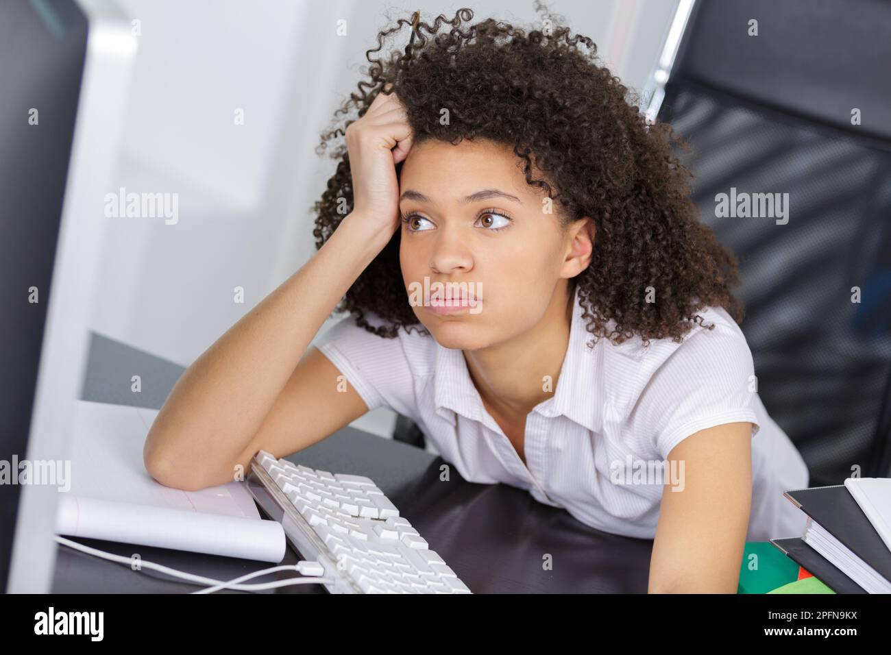 frustrated young woman sat at computer sighing Stock Photo - Alamy