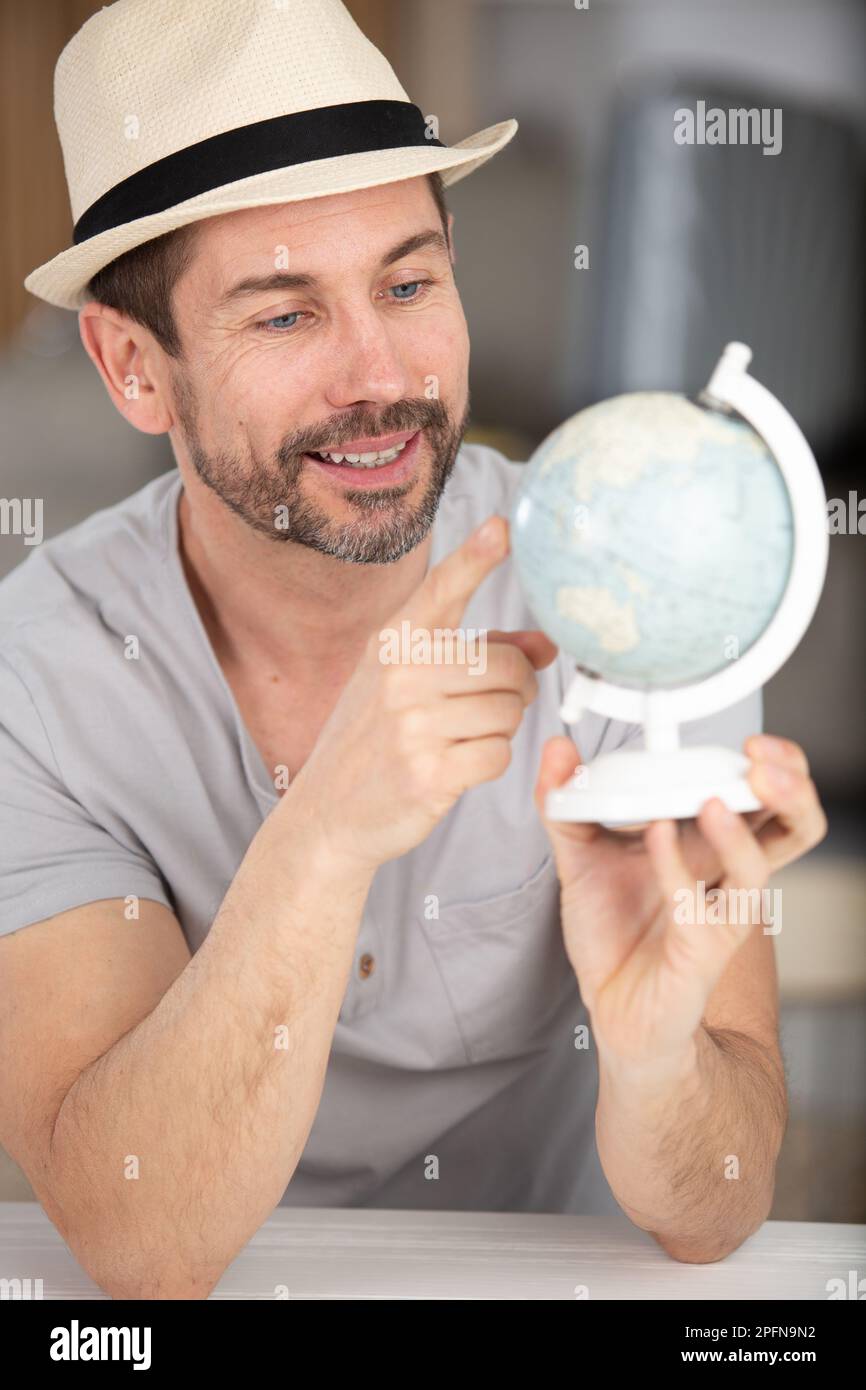 dreamy guy with globe thinks about which country to visit Stock Photo ...