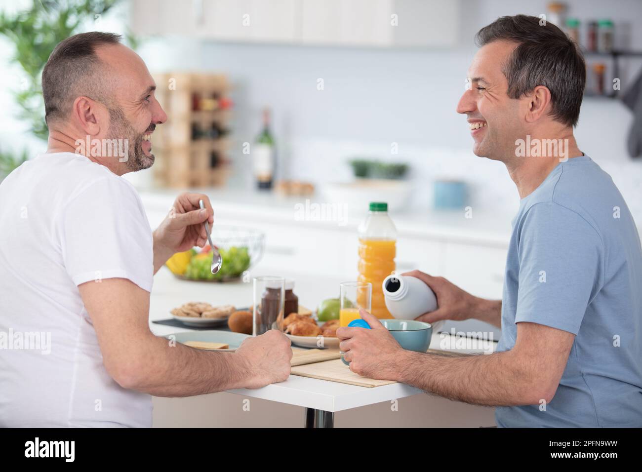 young gay couple have breakfast in the kitchen Stock Photo - Alamy
