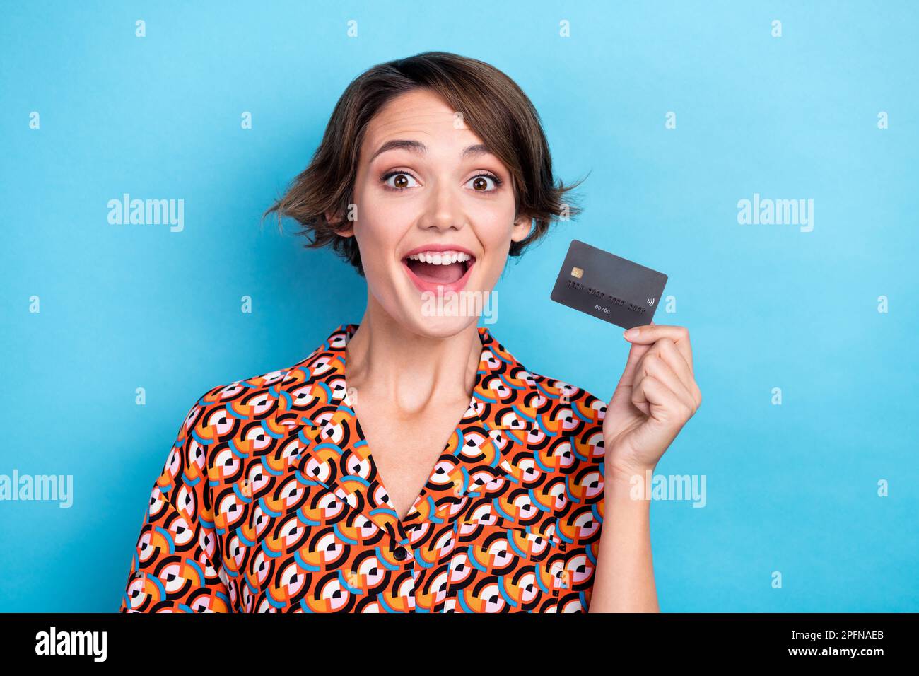 Portrait of astonished pretty person hand hold show plastic debit card ...