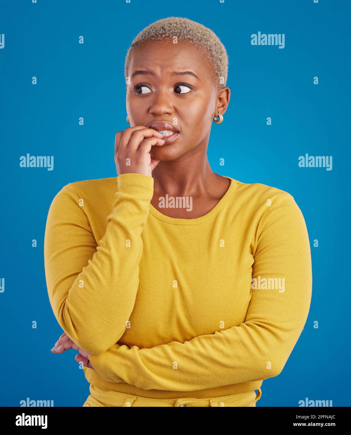 Nervous, worried and scared black woman in fear and bitting nails ...