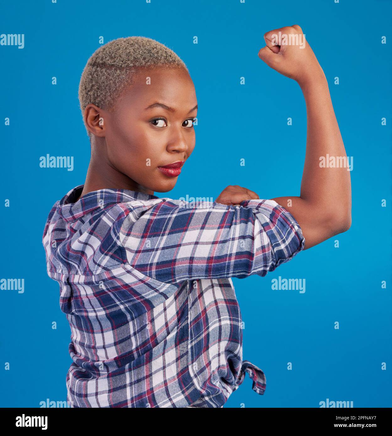Portrait, black woman and flex arms on blue background, studio and ...