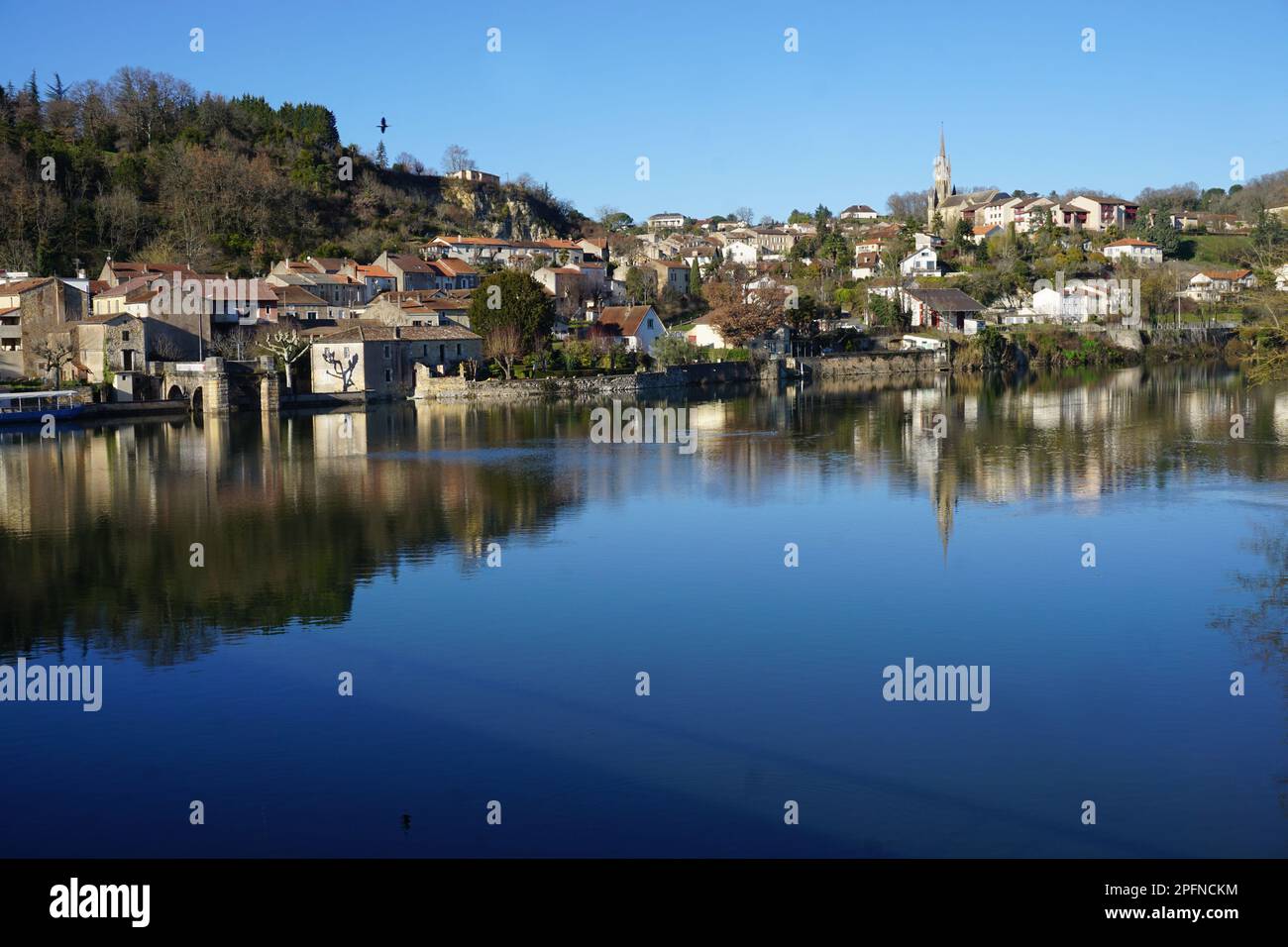 landscape with mirror reflection of the vlllage of Fumel in the river ...