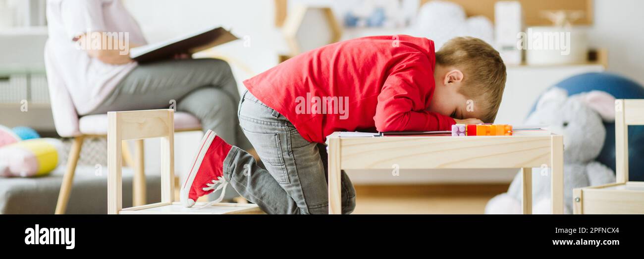 Cute little boy with ADHD during session with professional therapist ...