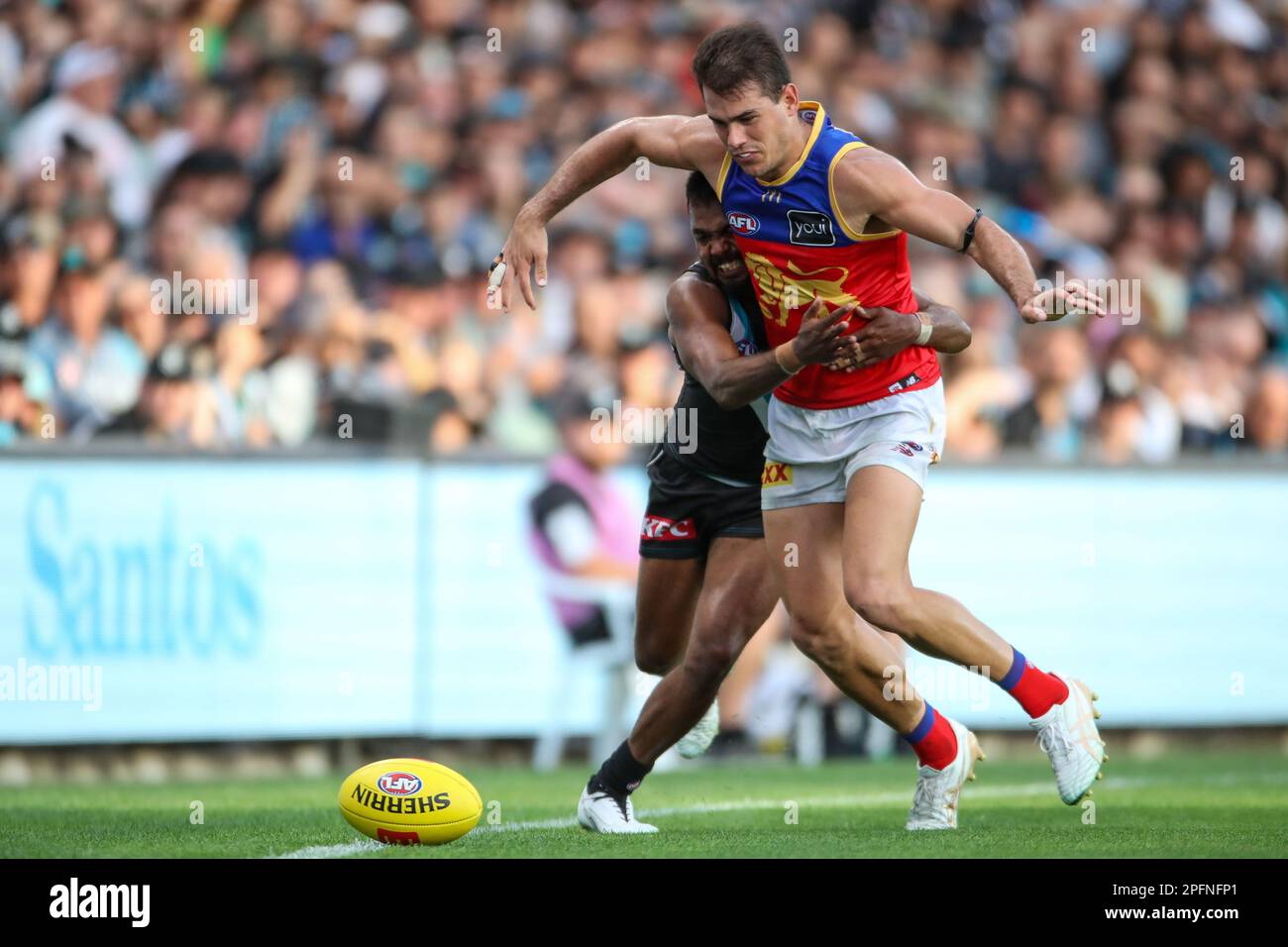 Junior Rioli of the Power is tackled by Brandon Starcevich of the Lions ...