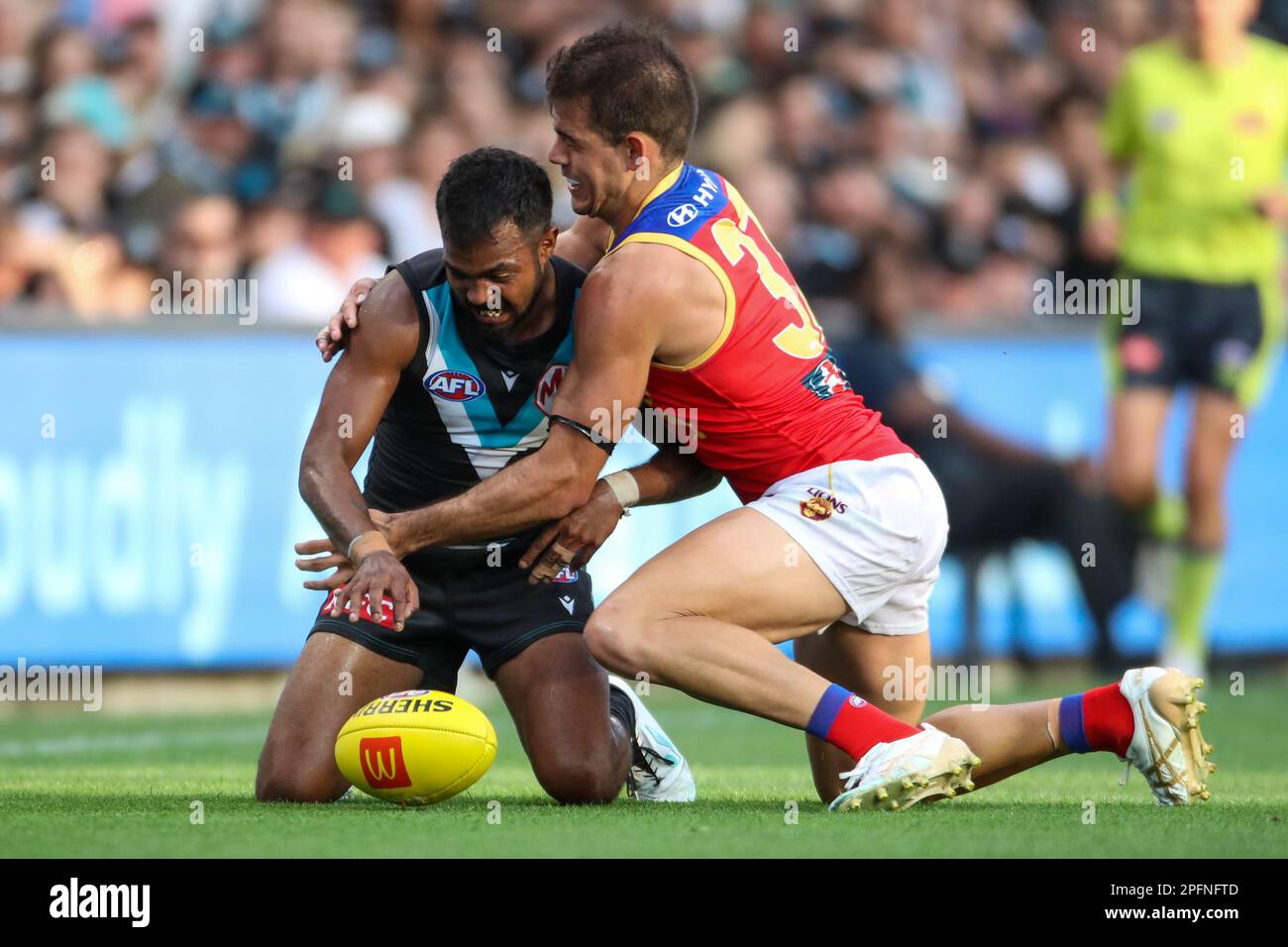 Junior Rioli of the Power is tackled by Brandon Starcevich of the Lions ...
