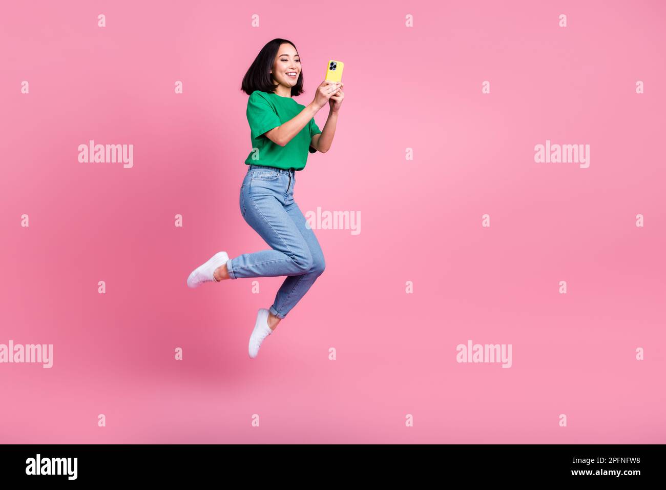 Full body photo of japanese jumping air carefree korean girl hold smartphone fast speed wireless ...