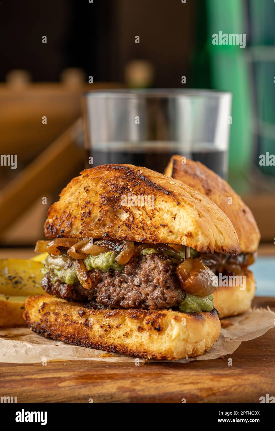 Caramelized onion burger with avocado sauce cut in half, with sauces ...