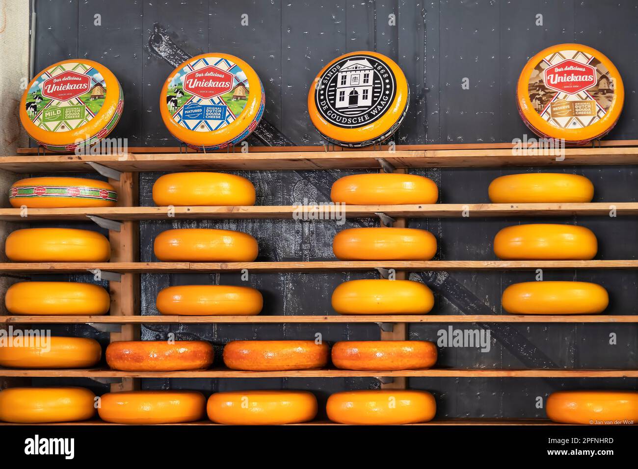 Large round cheeses on a wooden rack Stock Photo - Alamy