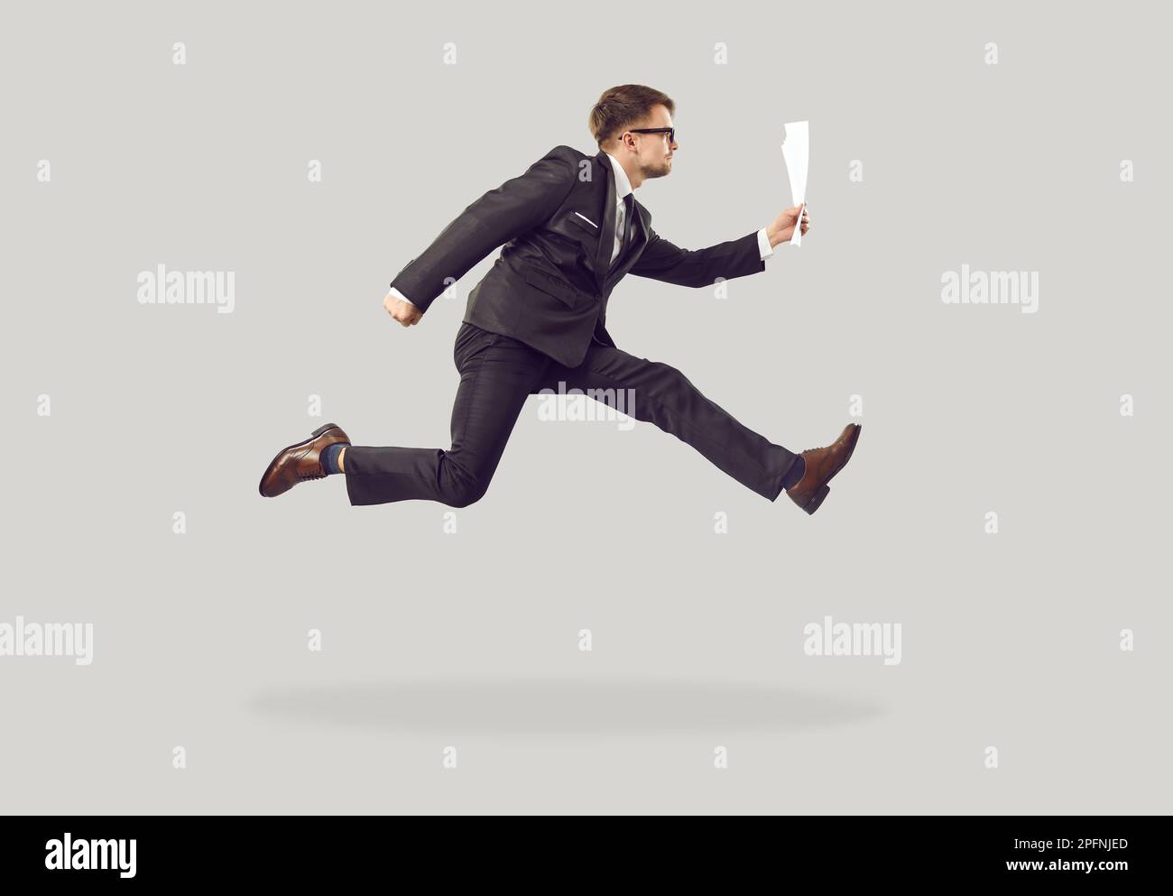 Funny young office worker in suit holding business documents and ...