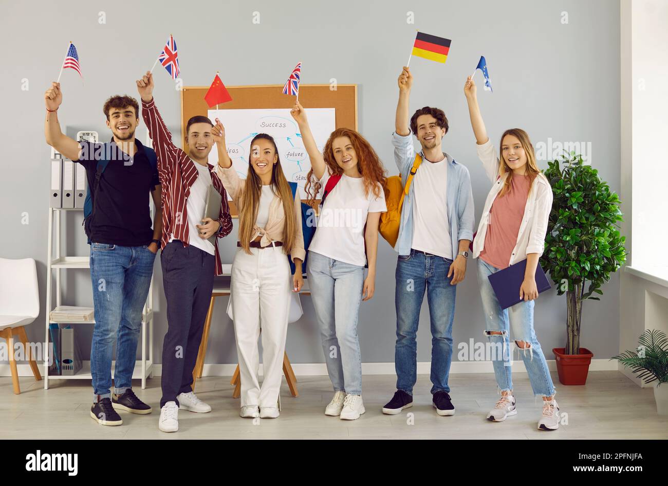 Portrait of cheerful international students standing in classroom ...