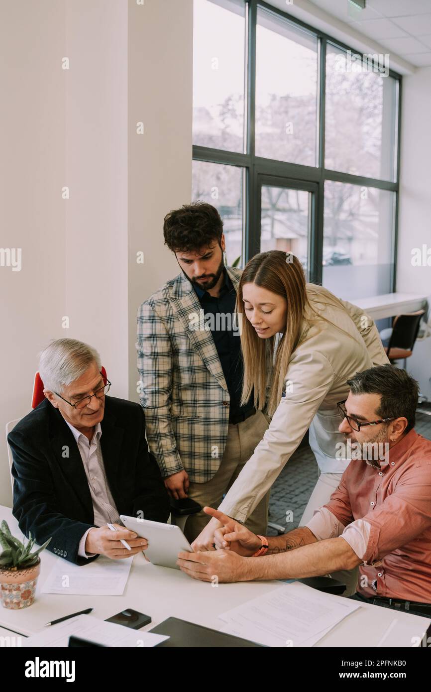 Four coworkers working together in the office. Young blonde woman ...