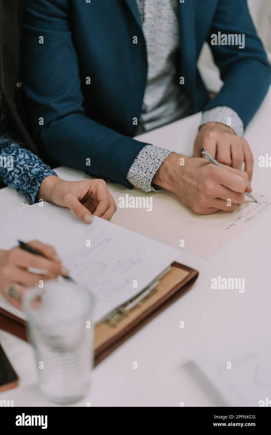 Two business people writing ideas at their papers. Close up photo Stock ...