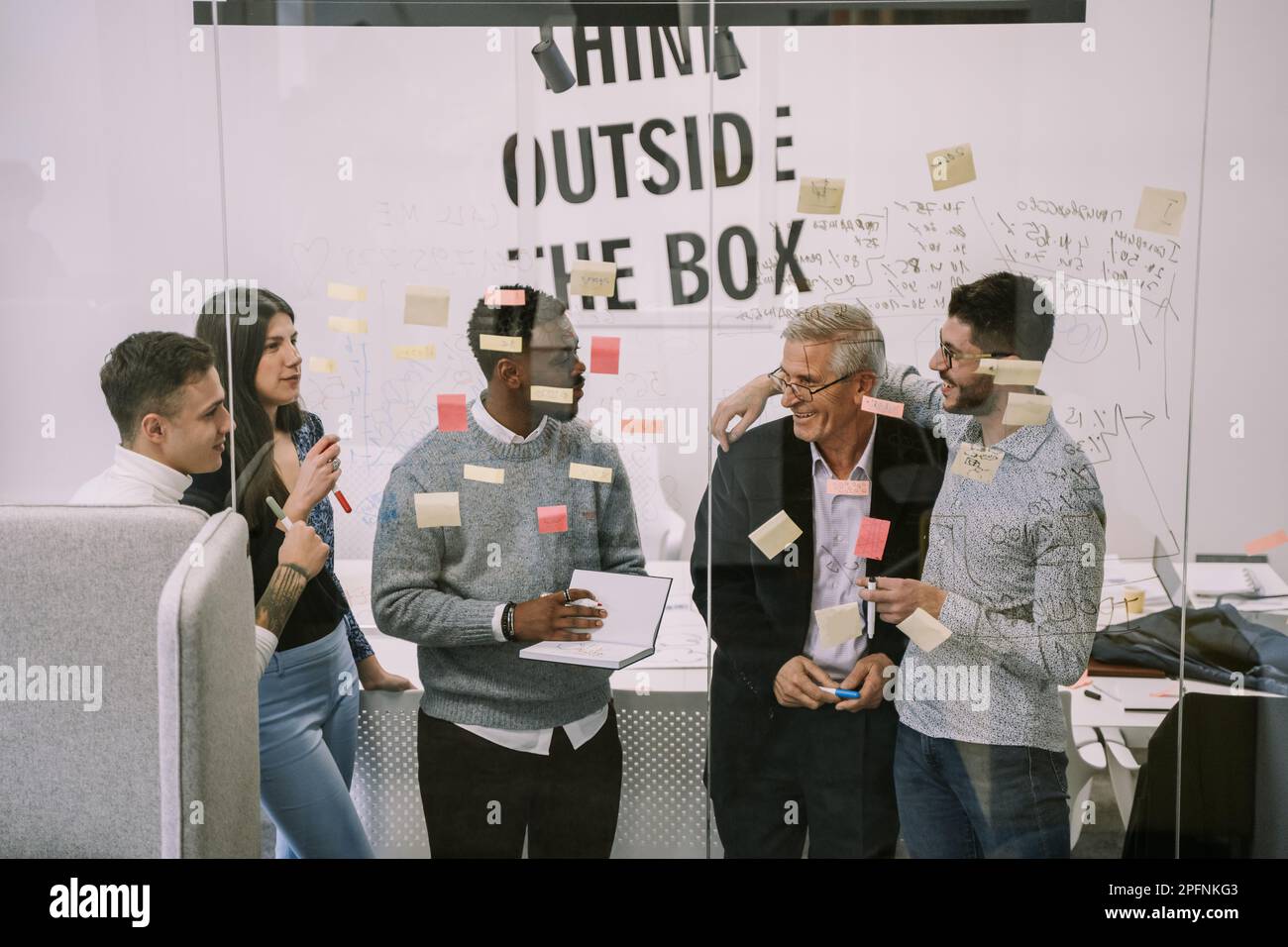 Diverse multi-generational group of people having fun while working in ...