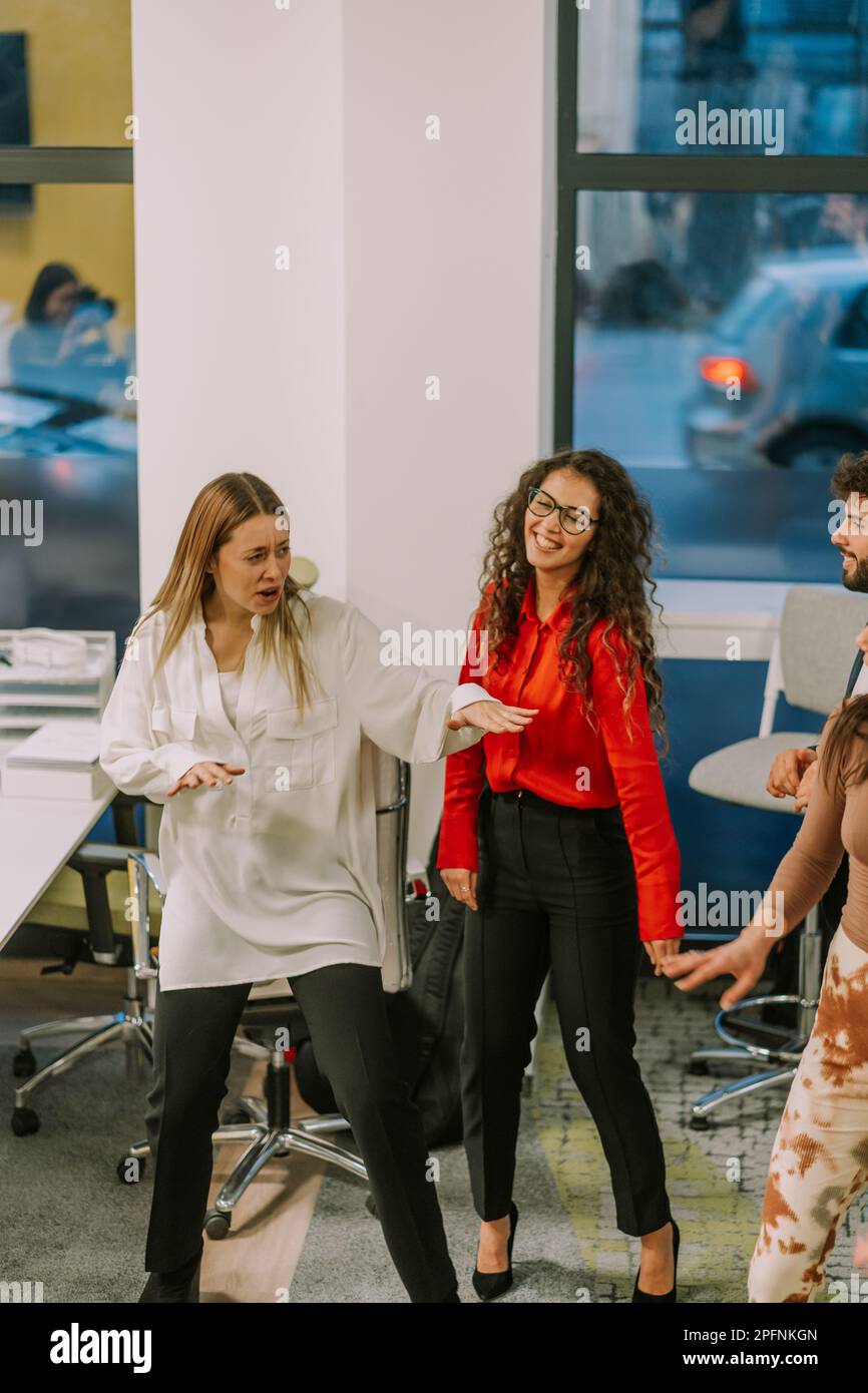 After hard day at work. young businesspeople dancing at the office ...