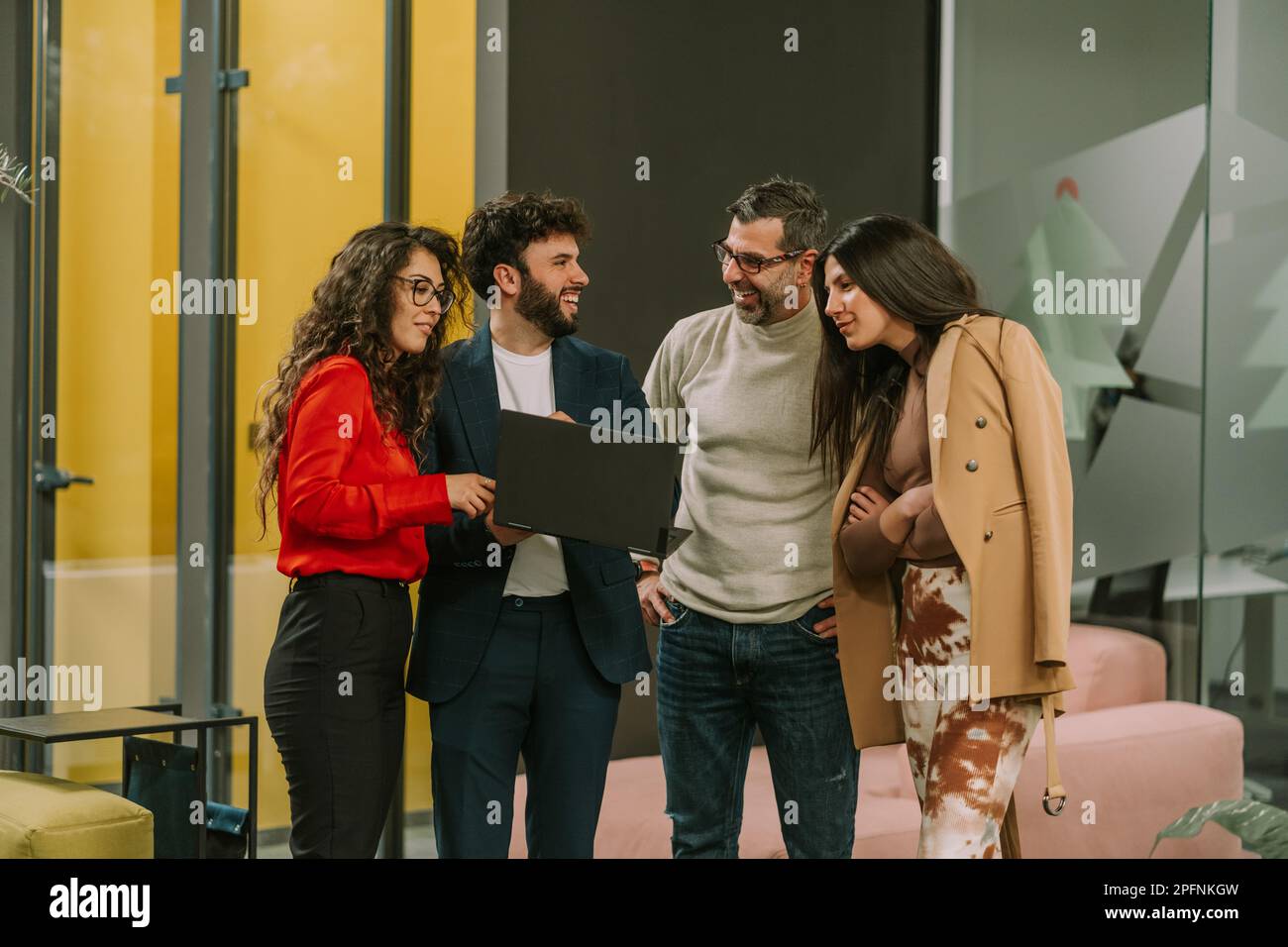 A middle-aged male person, manager, helping his junior colleagues with ...