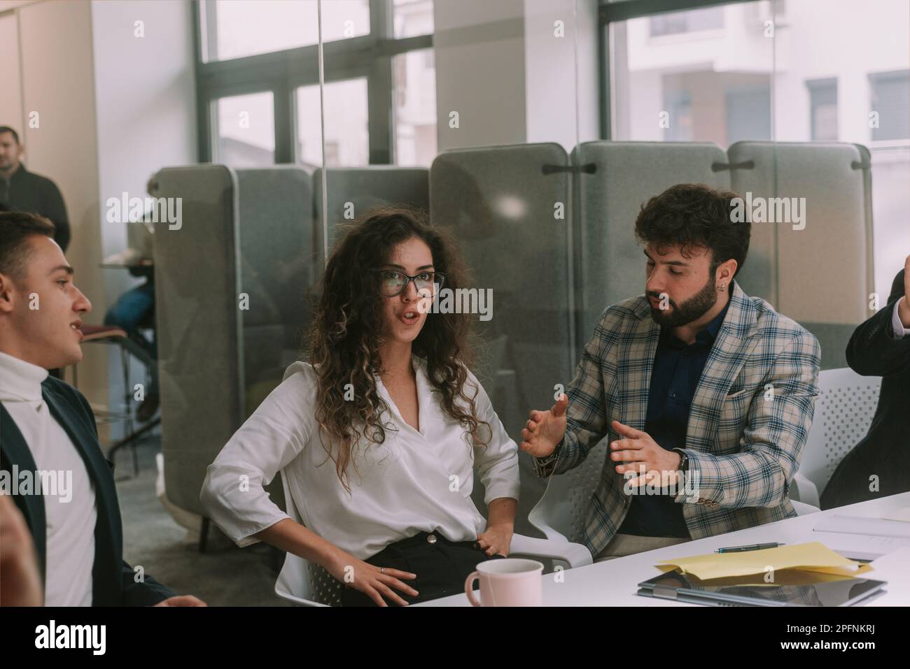 Angry business woman shouting while sitting with her colleagues trying ...