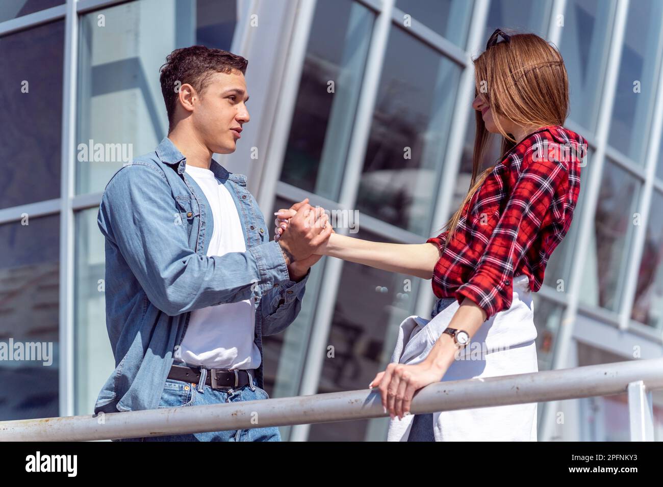 Cute couple talking while the is holding her hand Stock Photo - Alamy