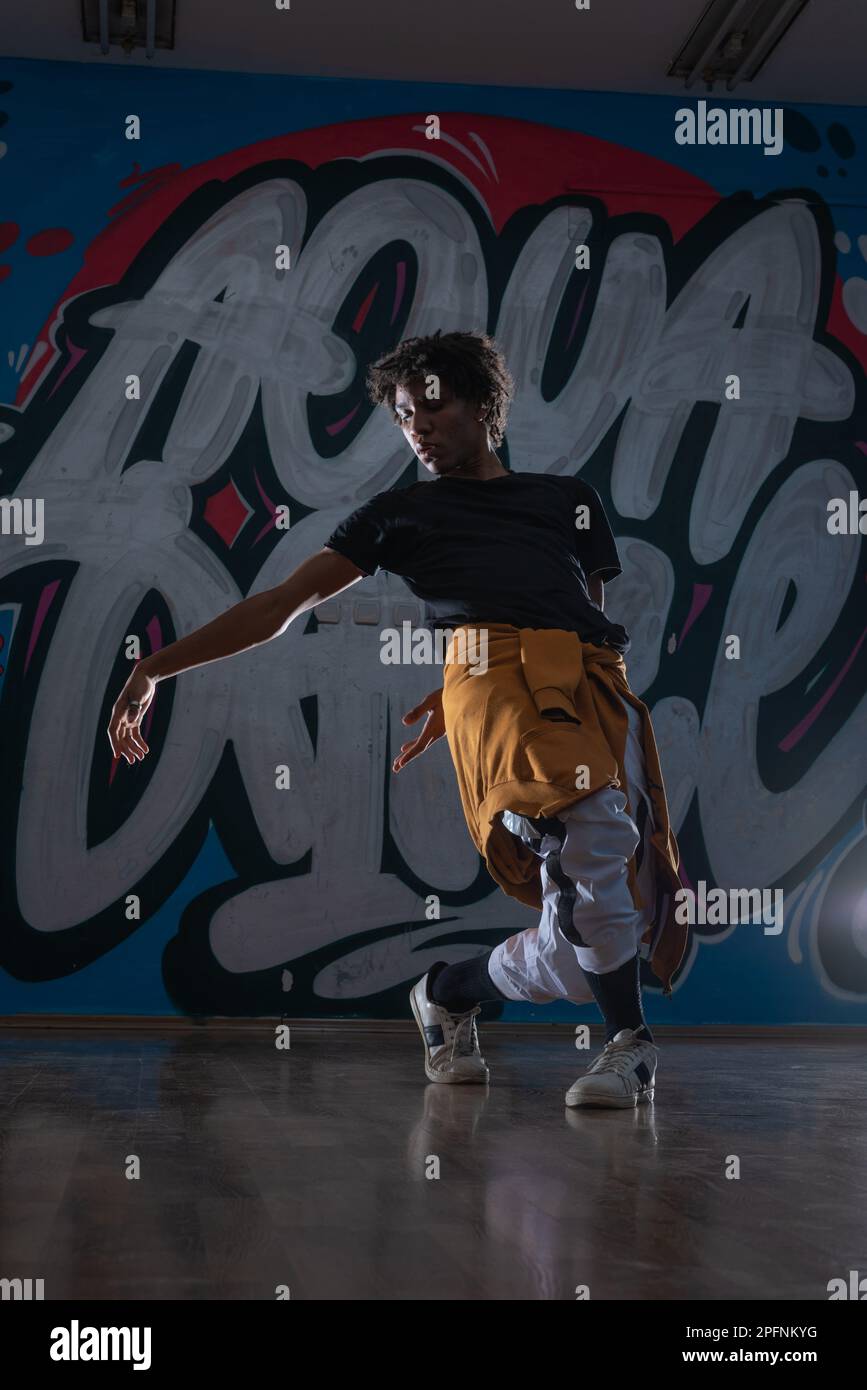 African American hip hop dancer (breakdancer) performing over graffiti ...